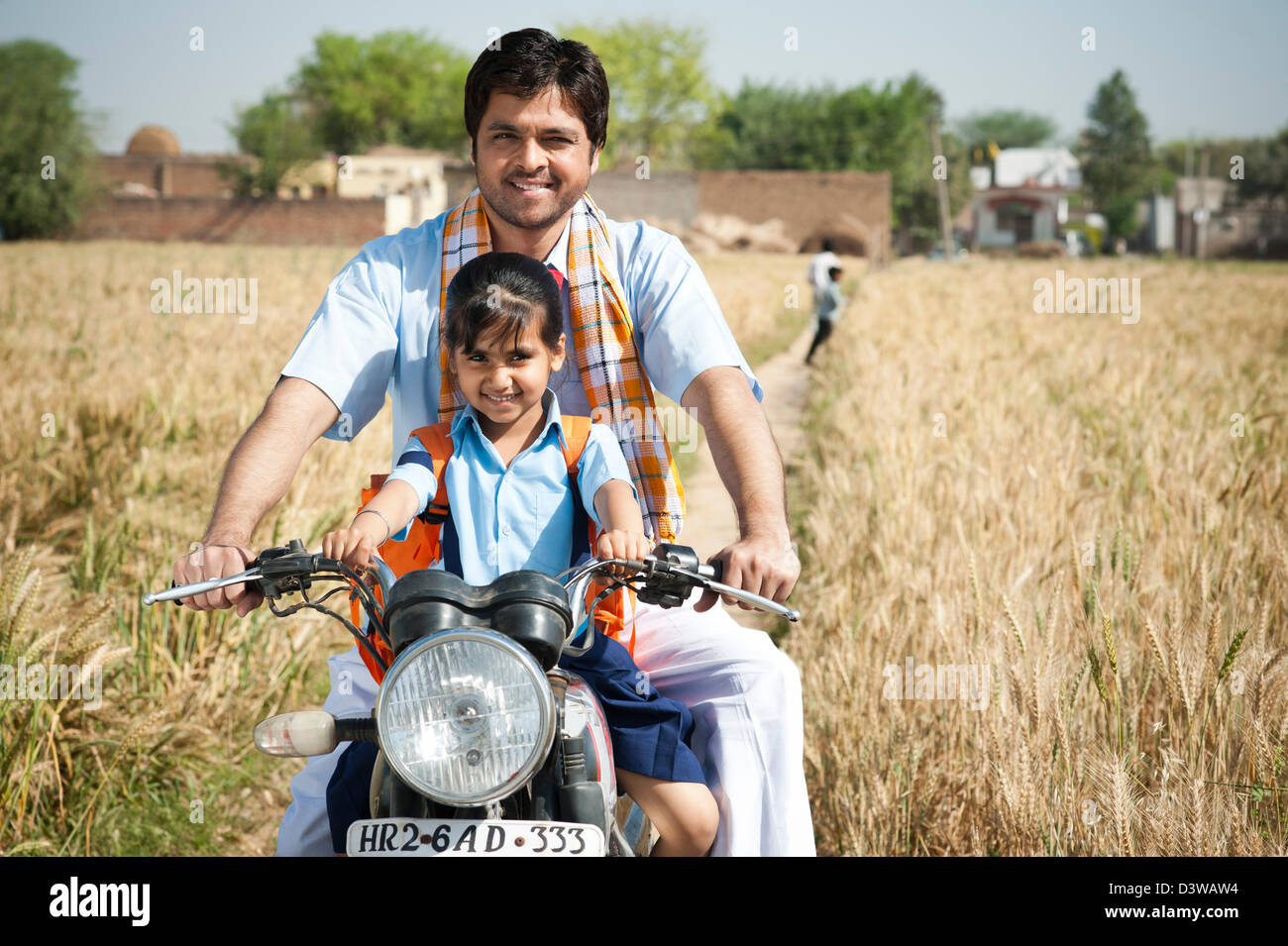 Farmer with his daughter riding a motorcycle in the field, Sohna ...