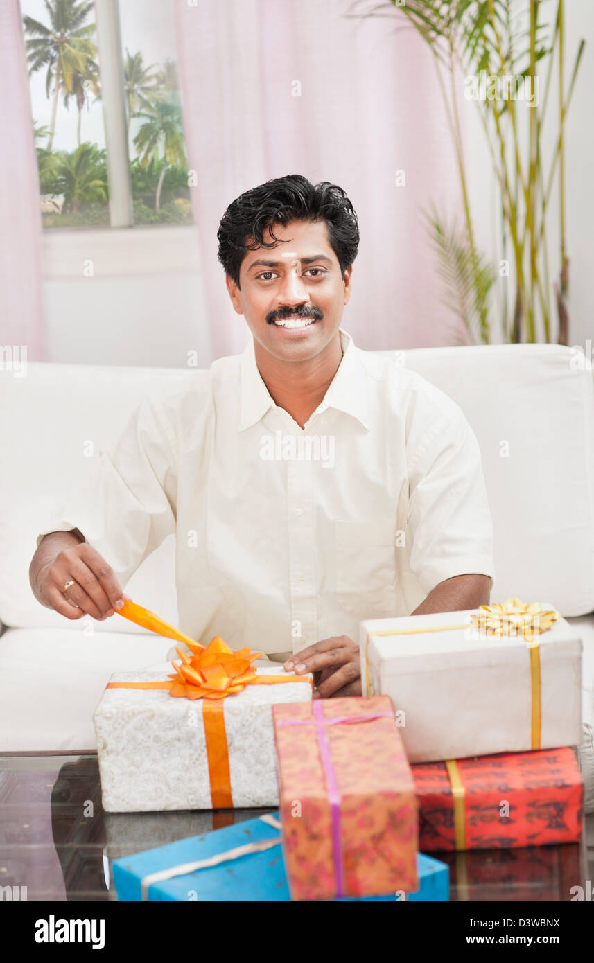 South Indian man smiling near gift boxes Stock Photo - Alamy