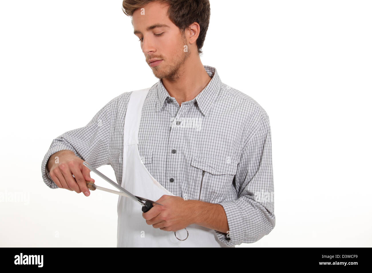 Young man sharpening knife Stock Photo - Alamy