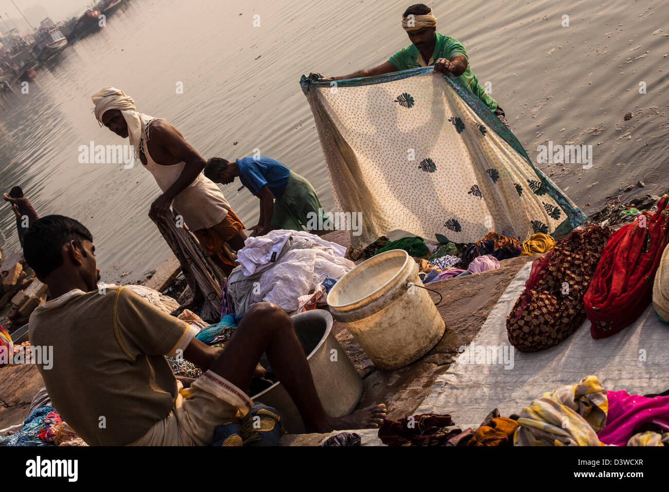 Indian men hand washing clothes in the Ganges river, Varanasi, India ...