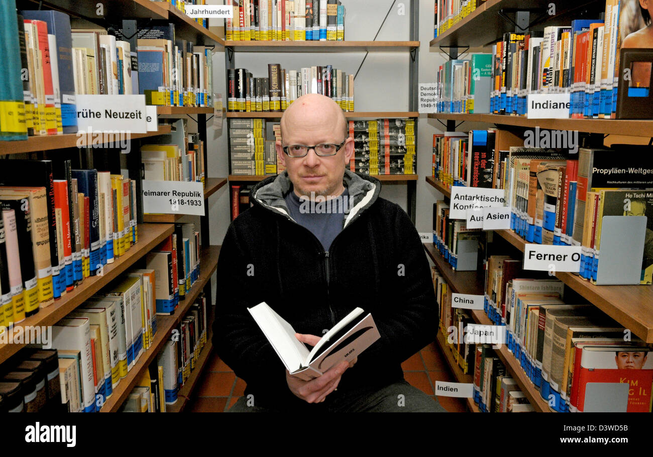 Journalist and author Timur Vermes sits with his book among shelves of ...