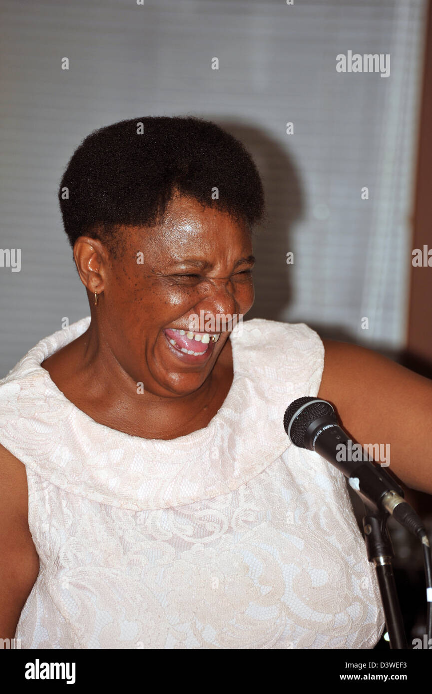 A woman laughing hard while giving a speech at a South African wedding ...