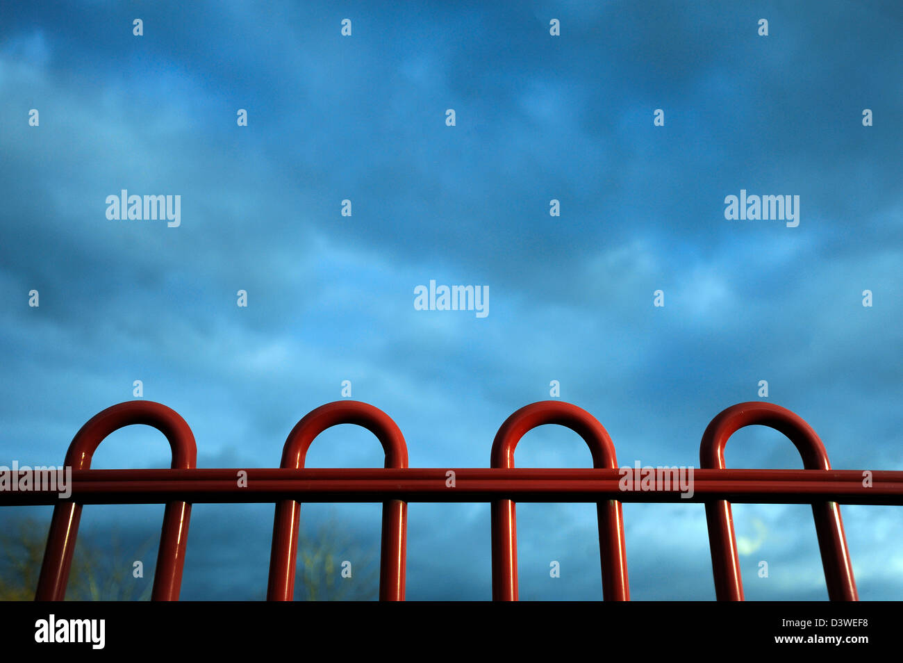 A red fence pictured against a dramatic sky Stock Photo - Alamy