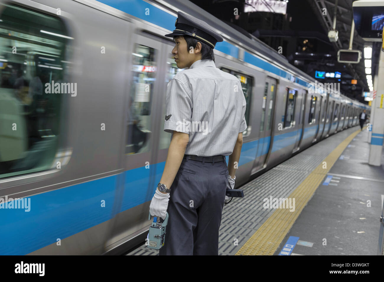 Metro worker watching the train leaving the station, Tokyo, Japan, Asia ...