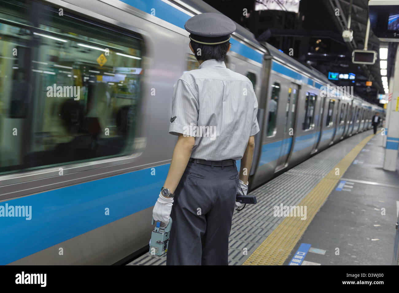 Metro worker watching the train leaving the station, Tokyo, Japan, Asia ...