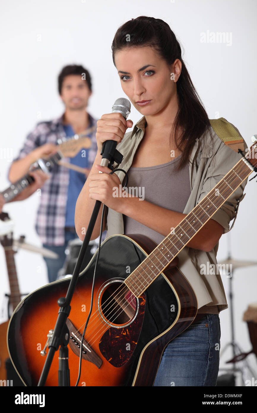 pretty brunette singing with band Stock Photo - Alamy