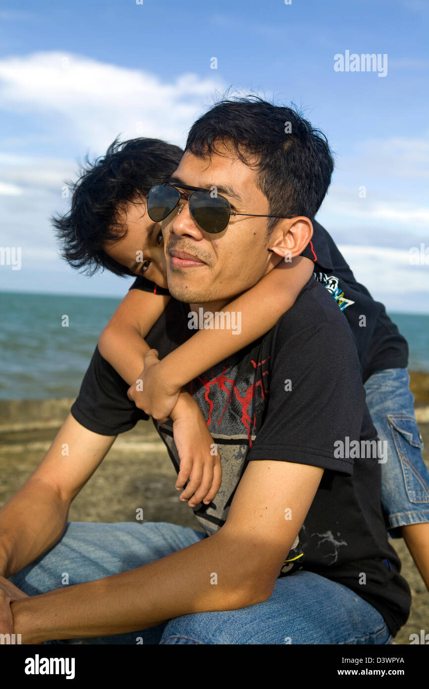 Filipino father and son hugging Stock Photo - Alamy