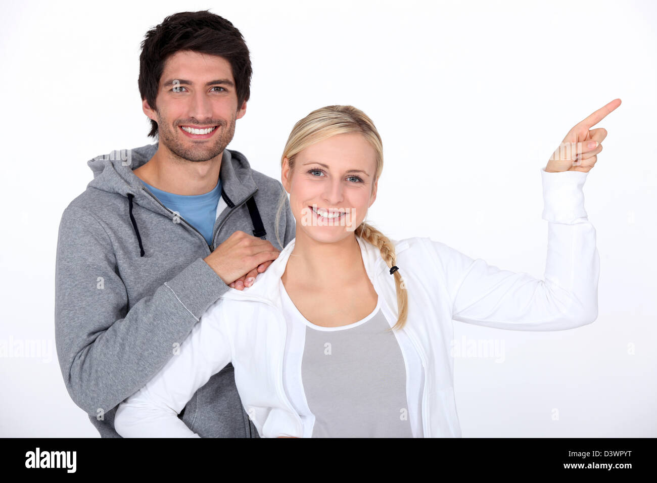 Casual couple pointing Stock Photo - Alamy