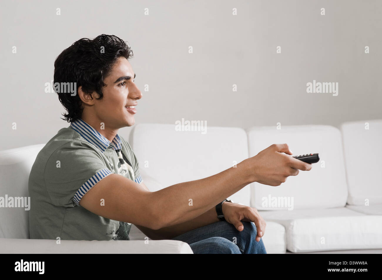 Man sitting on a couch watching television Stock Photo - Alamy