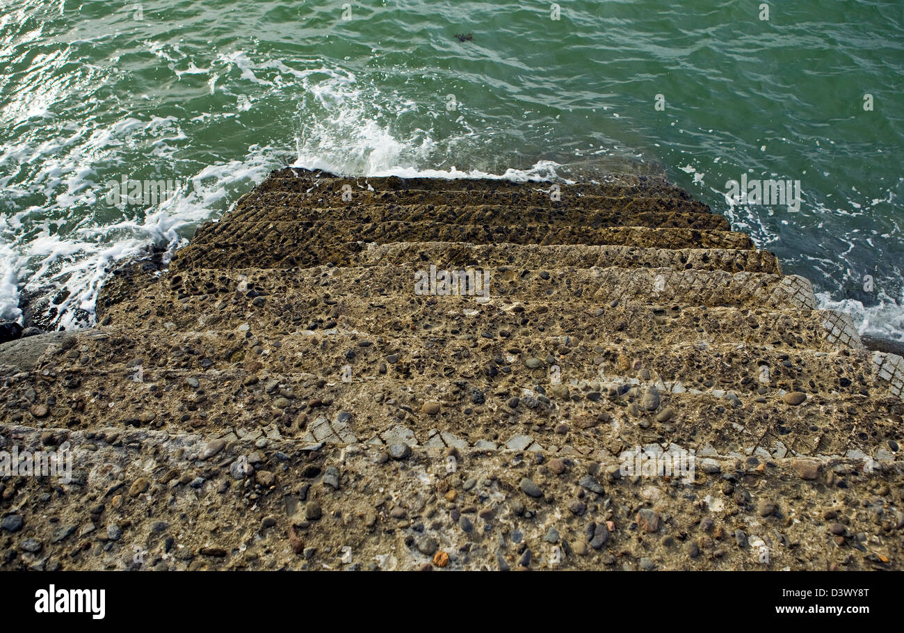 Saltwater eating away concrete seawall steps in the Philippines Stock ...