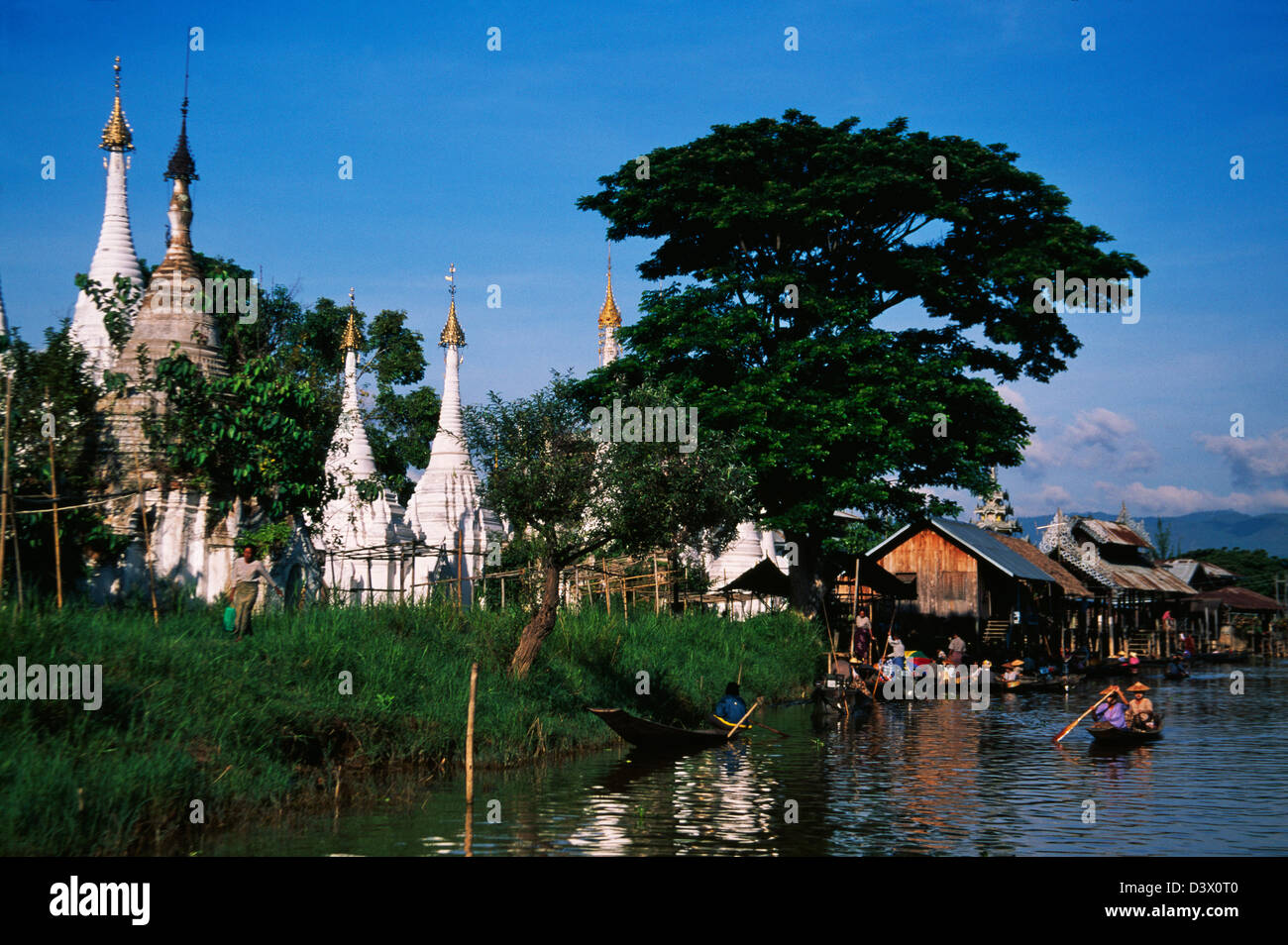 Floating market on the Inle Lake with pagodas and temples on the river ...