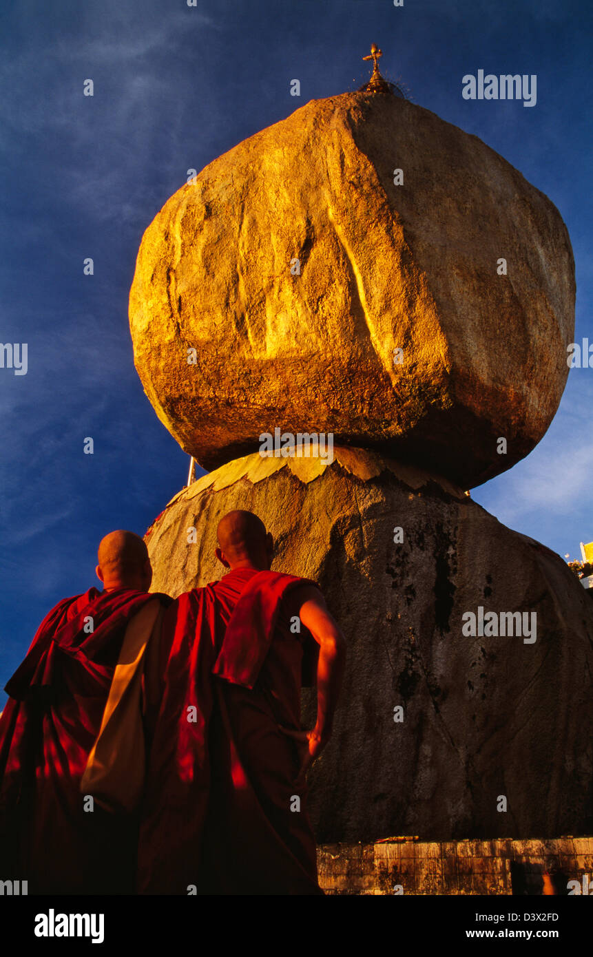 Two monks praying in front of the goldleafed balancing boulder (Gold ...