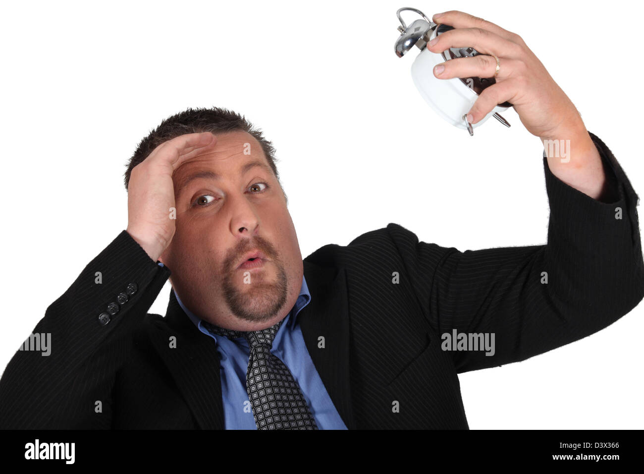 Panicked man in suit watching alarm clock Stock Photo - Alamy