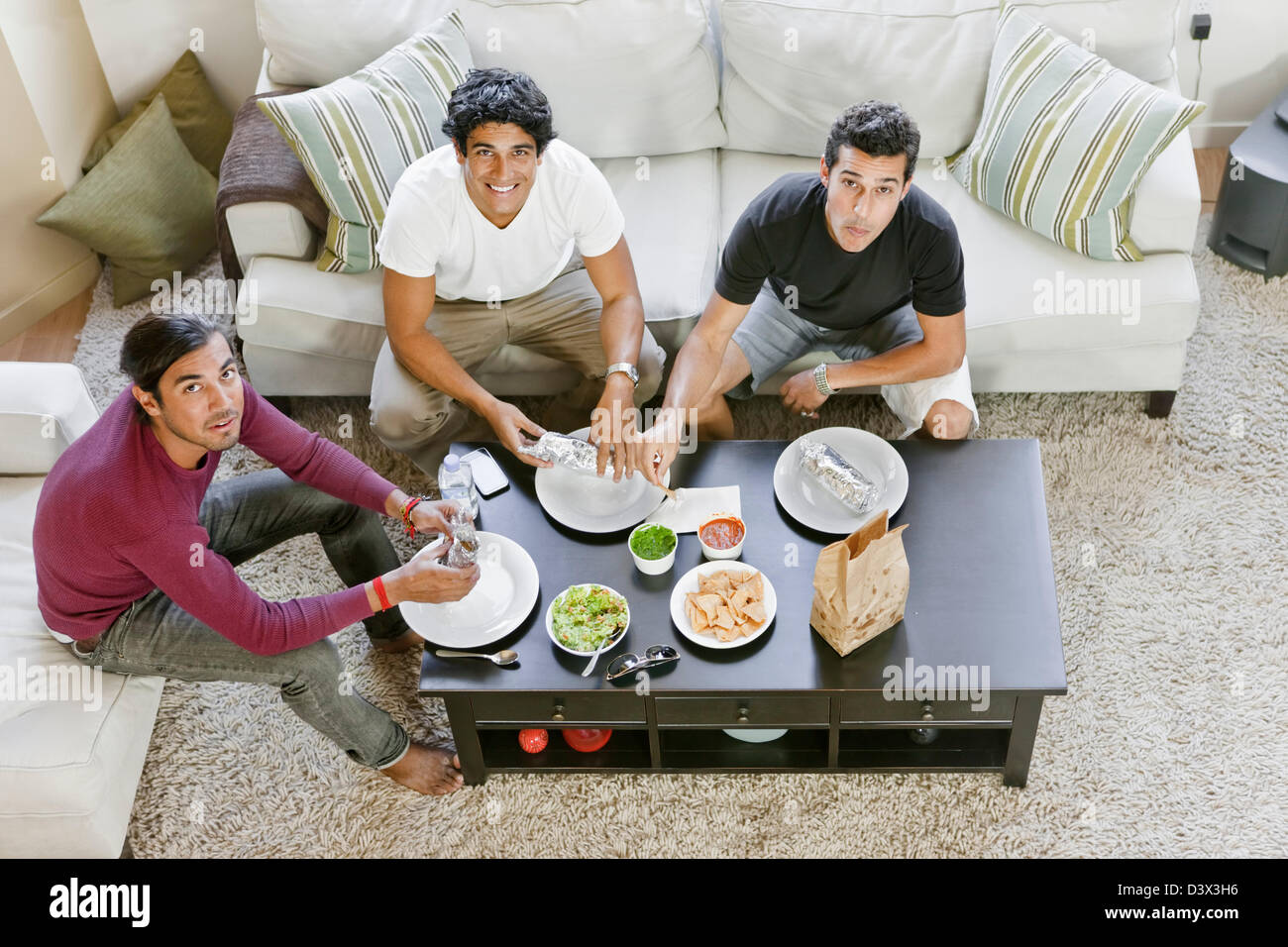 Hispanic-American Men Eating Burrito, Mexican Food in Living Room Stock ...