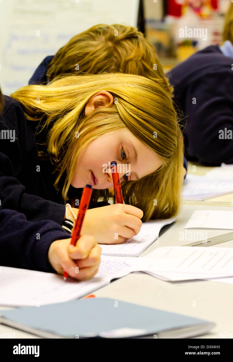 Primary school children writing in exercise books during a lesson Stock ...