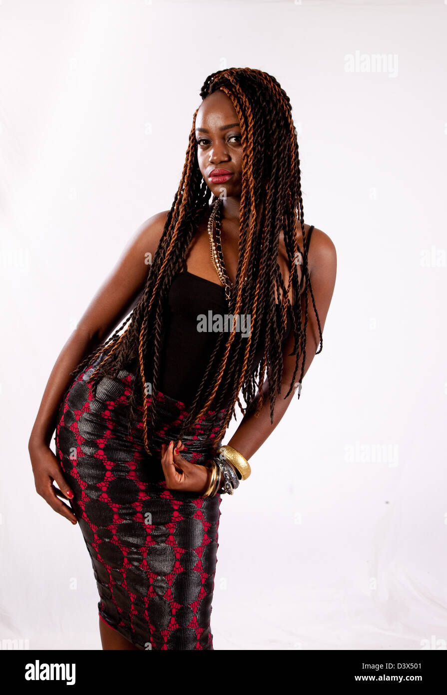 Pretty back woman in long dread locks, reaching to her waist, looking ...