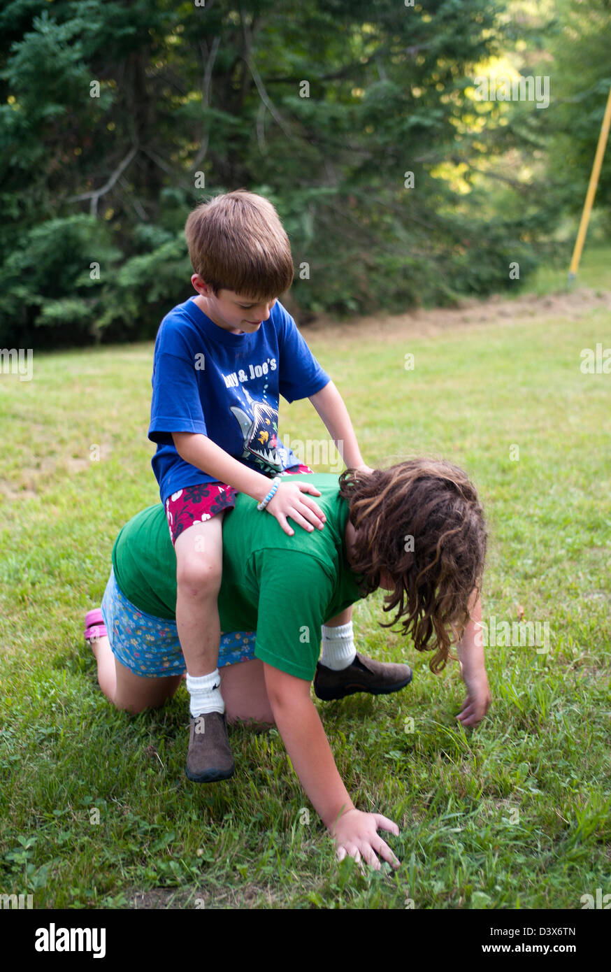 Children playing horse, boy on his sister Stock Photo - Alamy