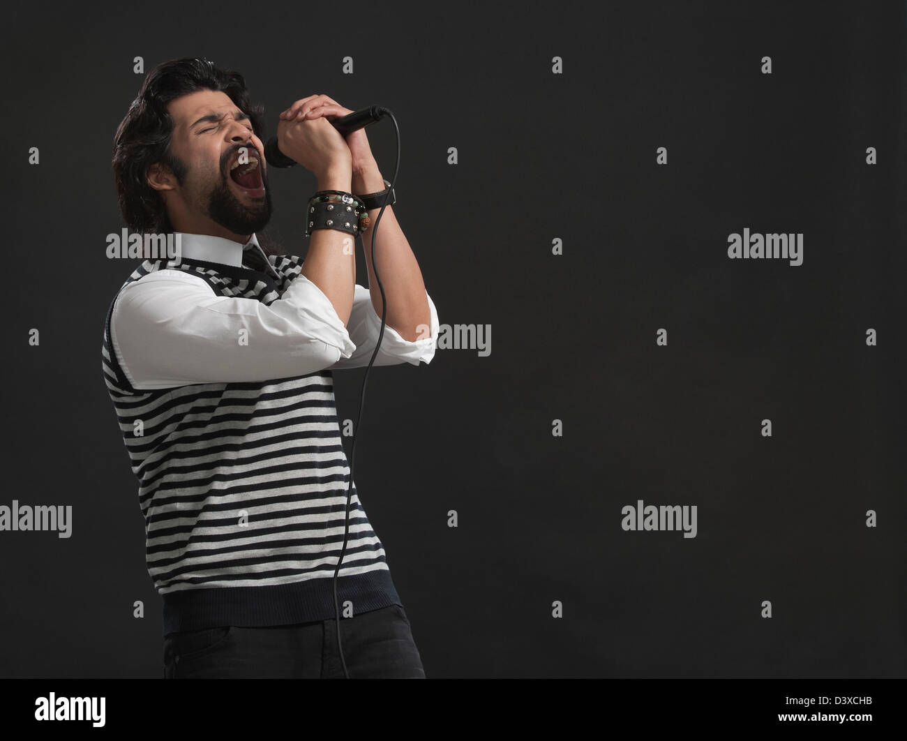 Singer holding a mike and singing Stock Photo - Alamy