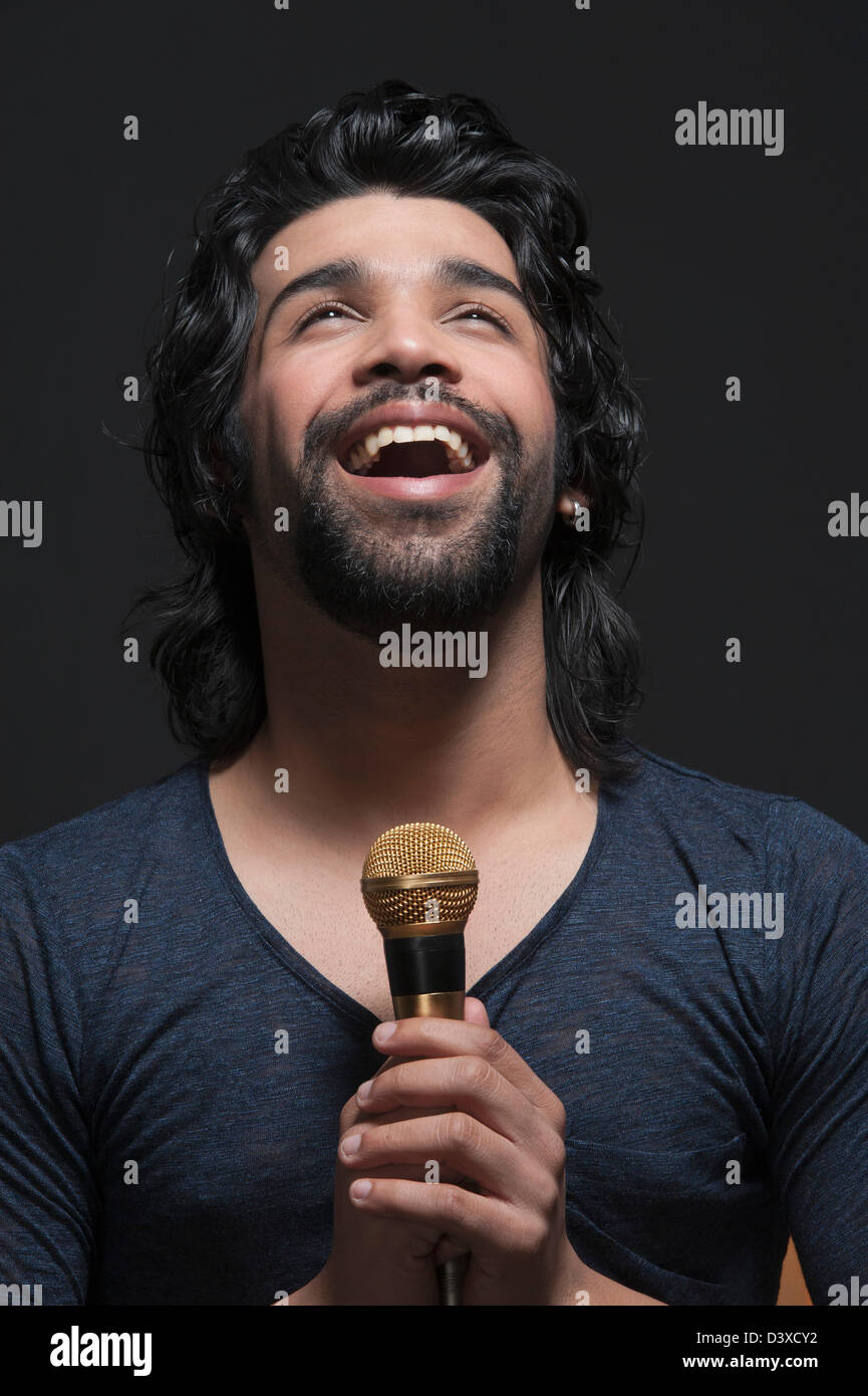Singer holding a mike and singing Stock Photo - Alamy