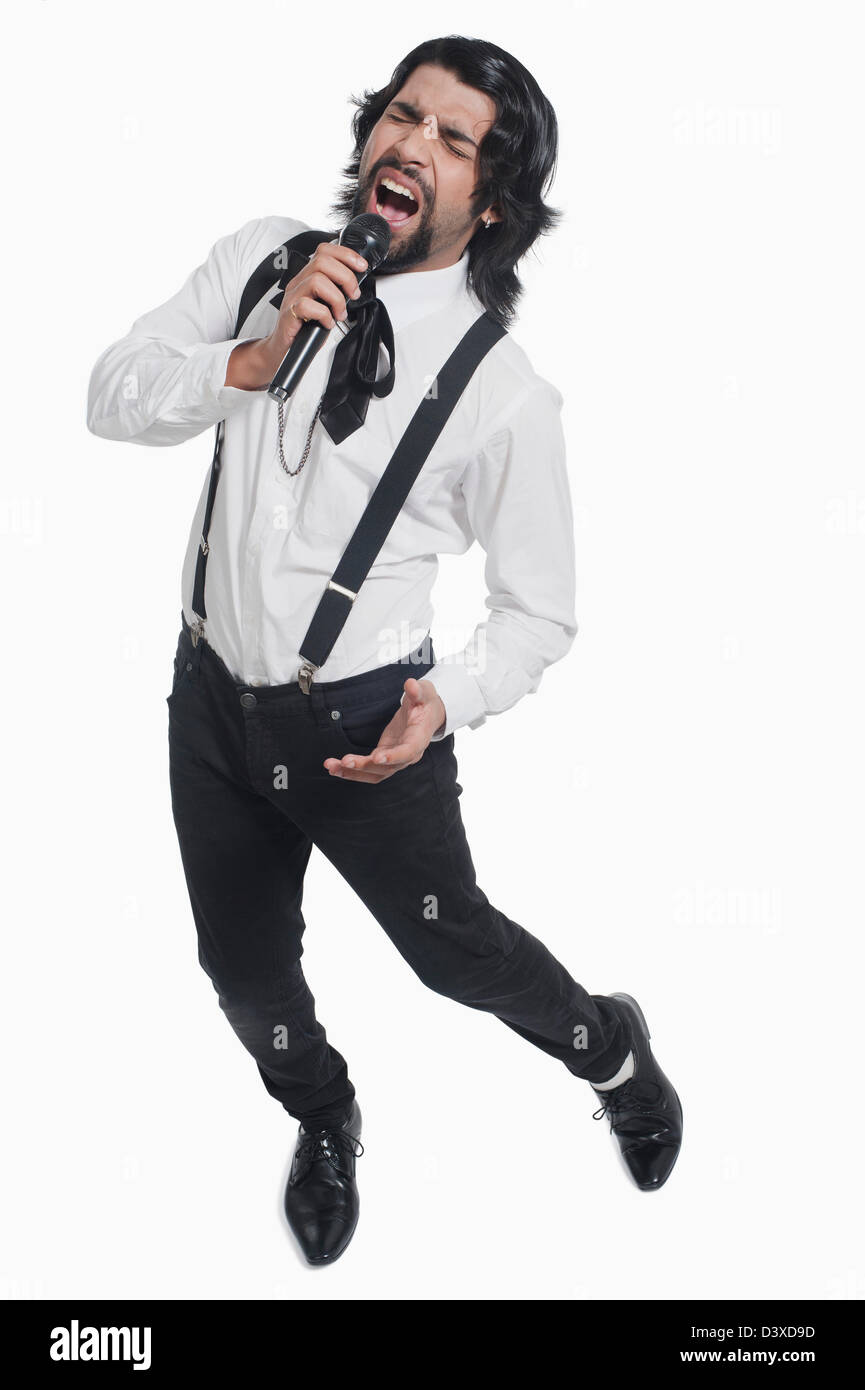 Singer holding a mike and singing Stock Photo - Alamy