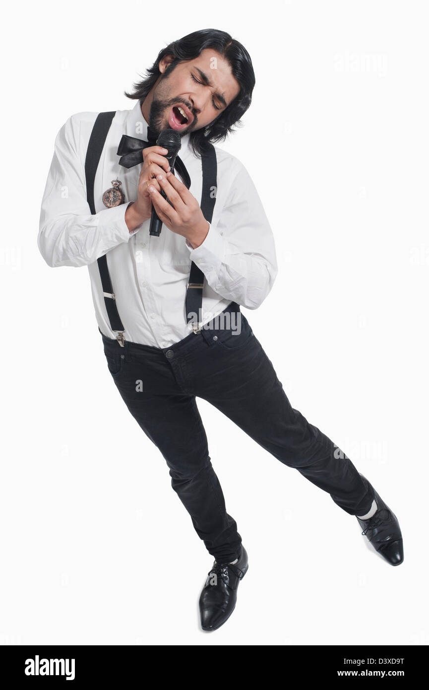 Singer holding a mike and singing Stock Photo - Alamy