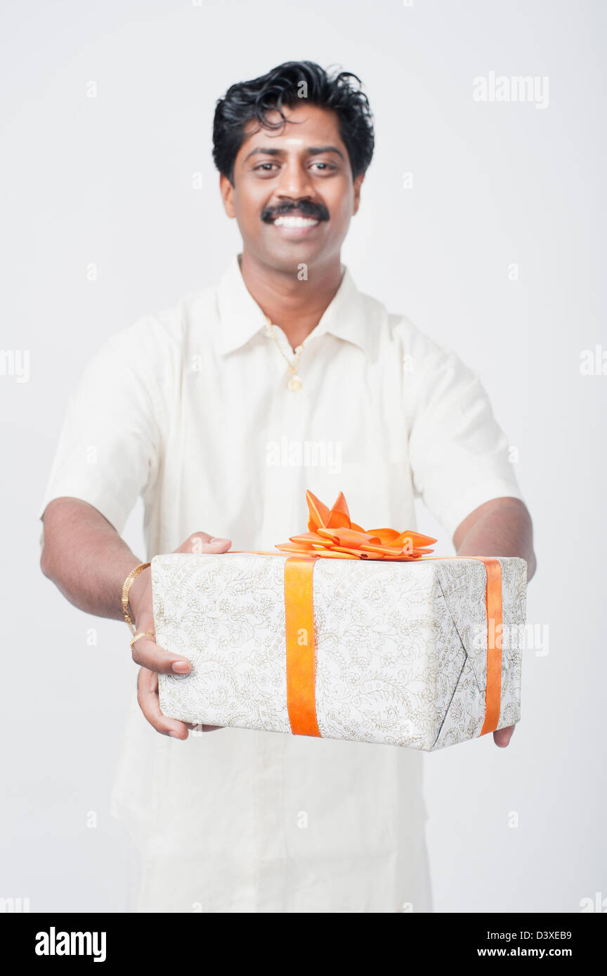 South Indian man giving a gift box Stock Photo - Alamy