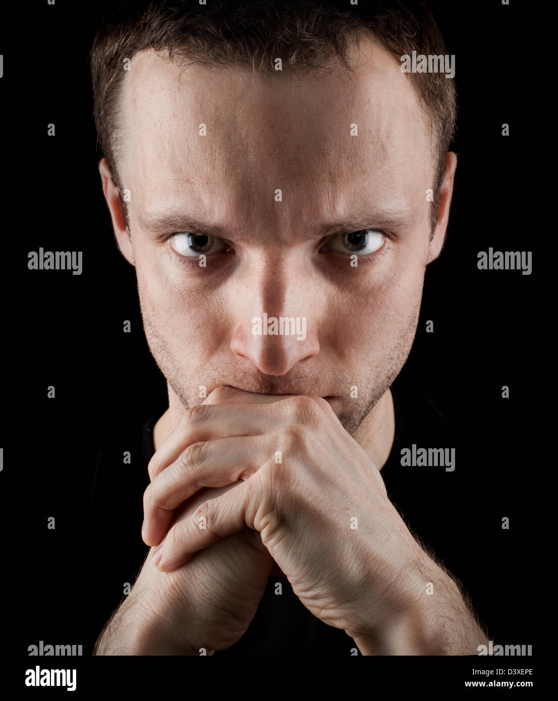 Serious young Caucasian man's portrait. Close-up face with hands on ...