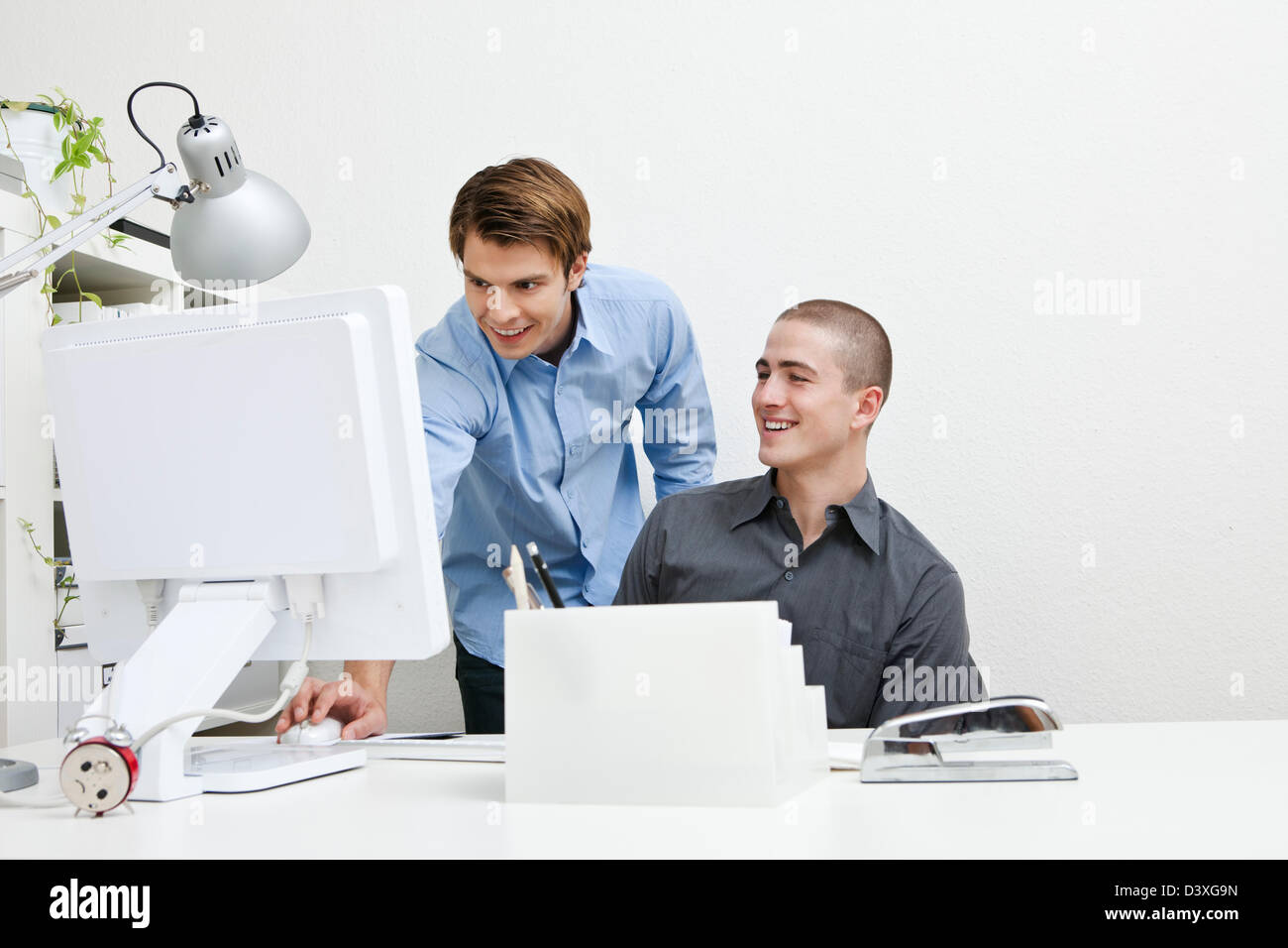 senior IT professional having fun training new office computer staff ...