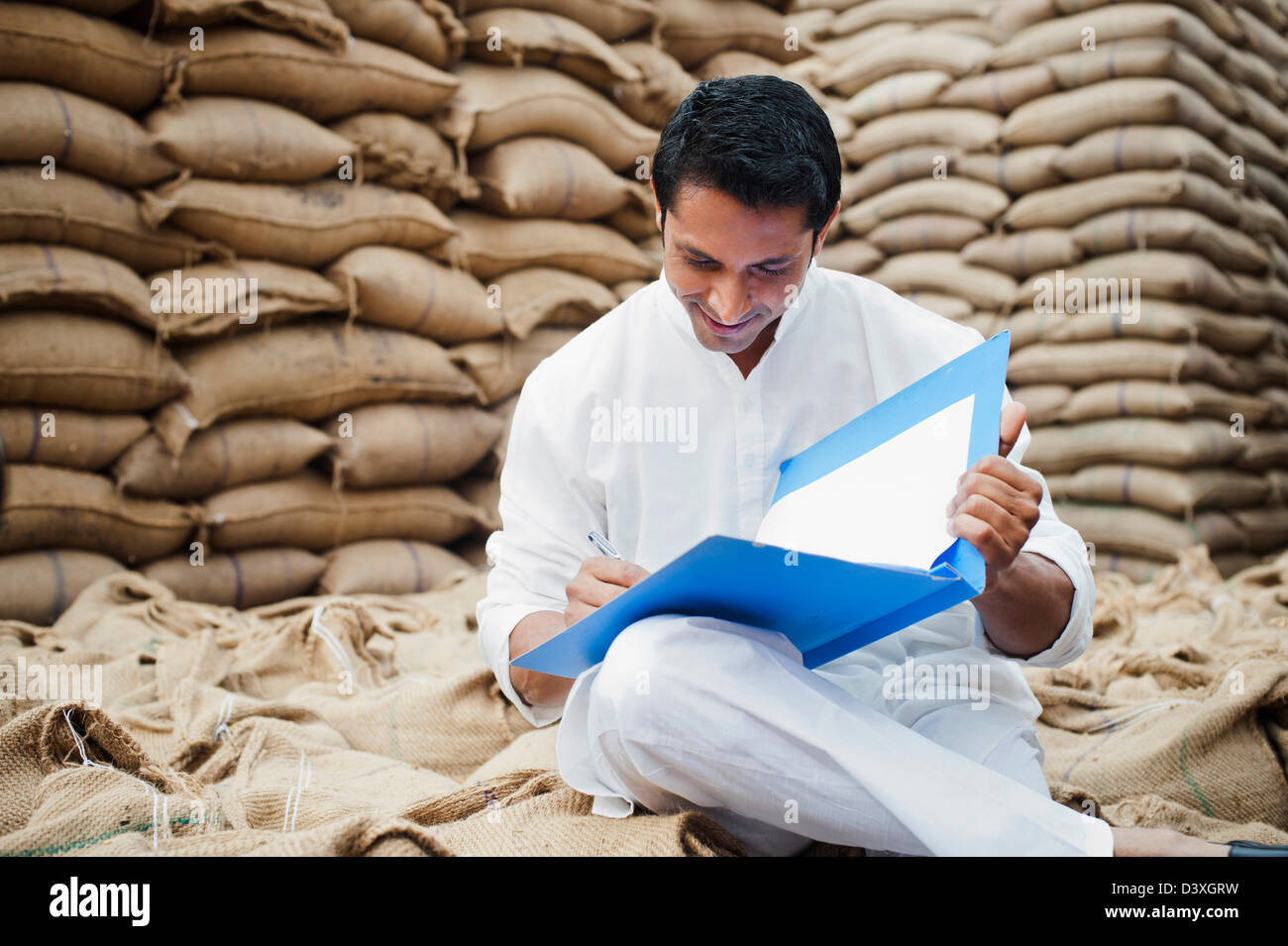 Man sitting on wheat sack holding a file, Anaj Mandi, Sohna, Gurgaon ...