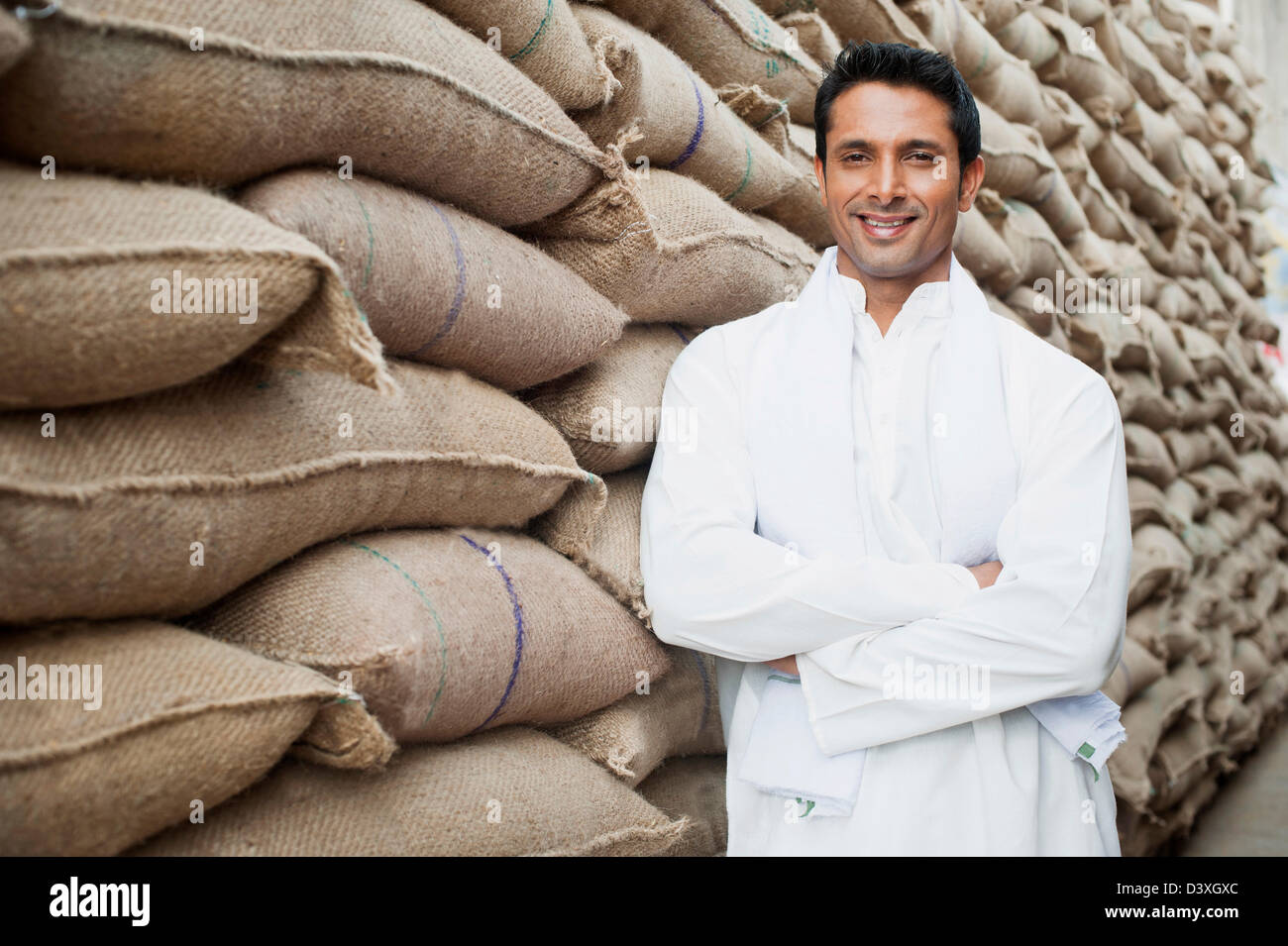Man standing near stacks of wheat sacks in a warehouse, Anaj Mandi ...