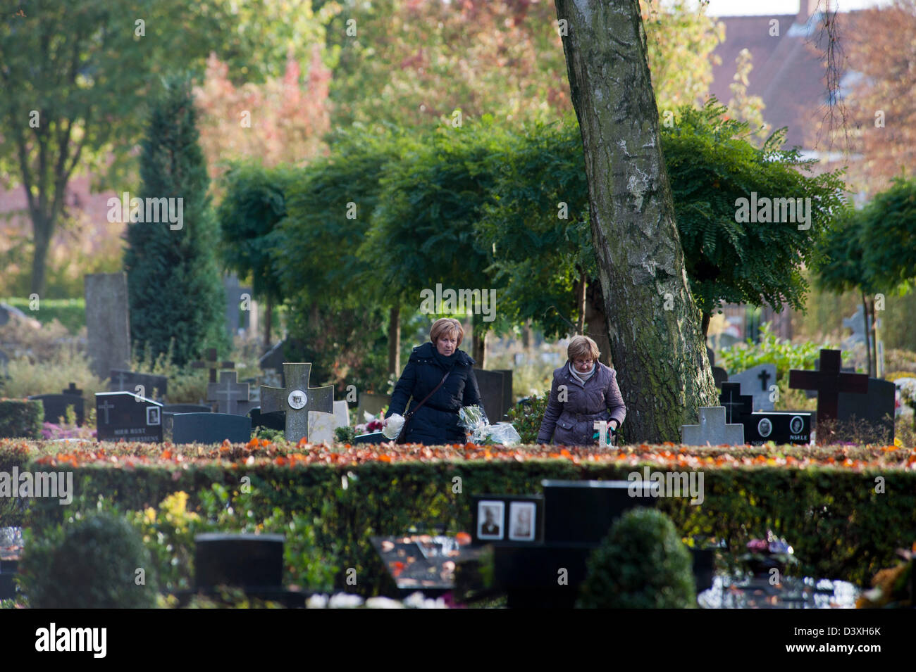 Two ladies, sisters preparing the graves of their loved ones for All ...