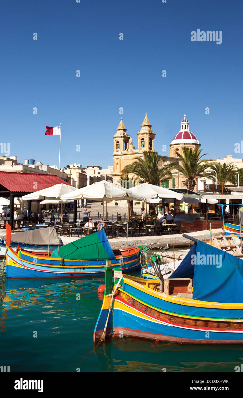 Outdoor cafe and traditional Maltese fishing boat.Marsaxlokk,Malta ...