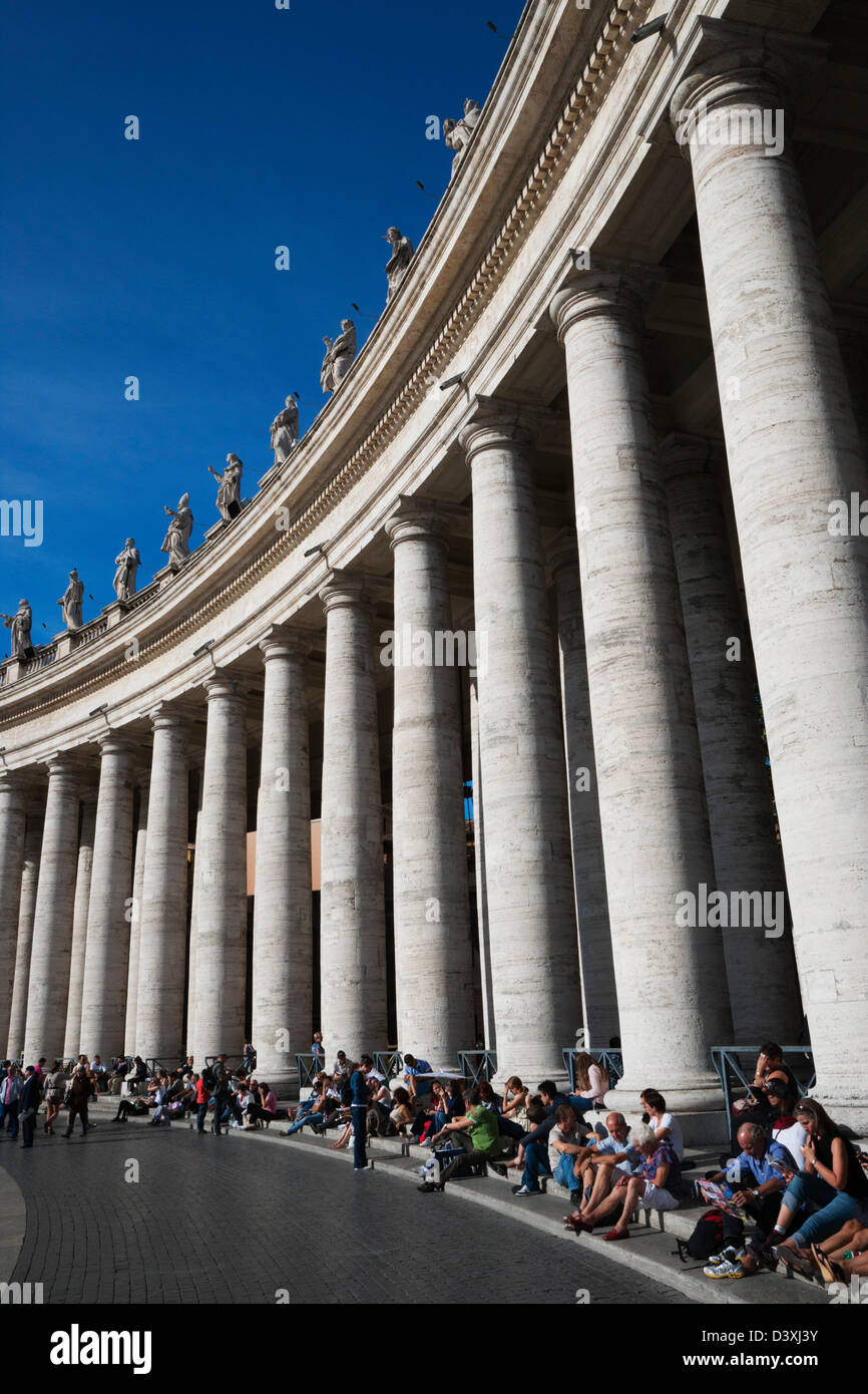 Tourists sitting on steps near columns, Berninis Column, St. Peters ...