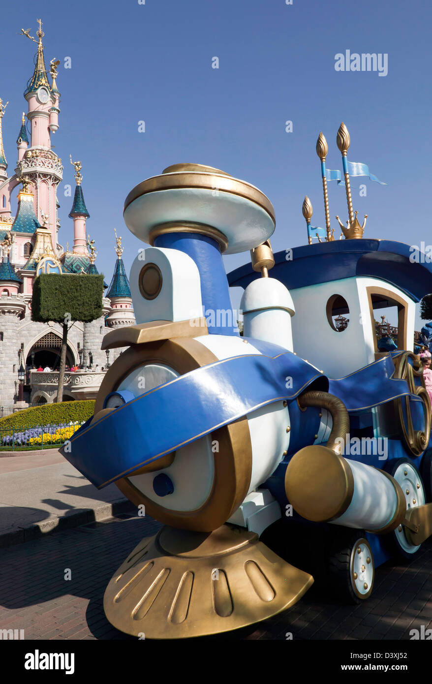 A mini themed parade, headed by a model locomotive, passes in front of ...