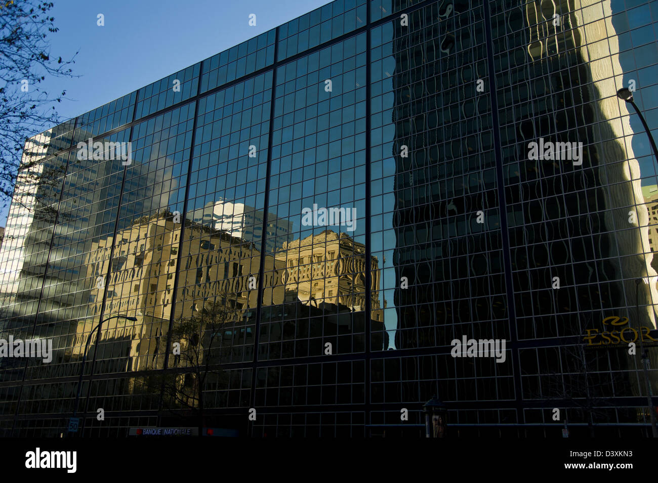 Buildings are reflected in the dark mirrored glass exterior of another ...