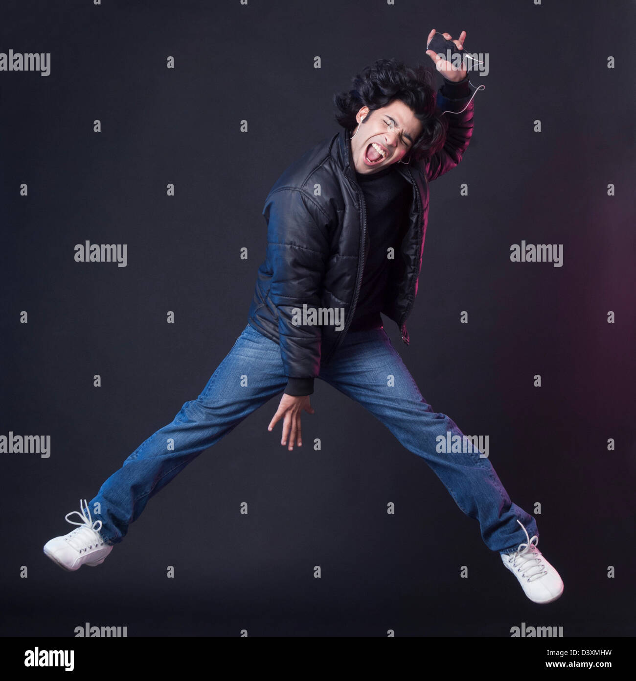 Man listening to MP3 player and jumping in excitement Stock Photo - Alamy