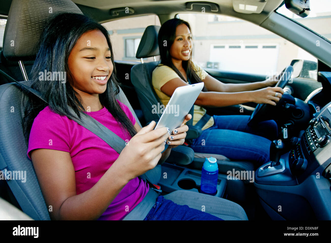 Girl using digital tablet in car Stock Photo - Alamy