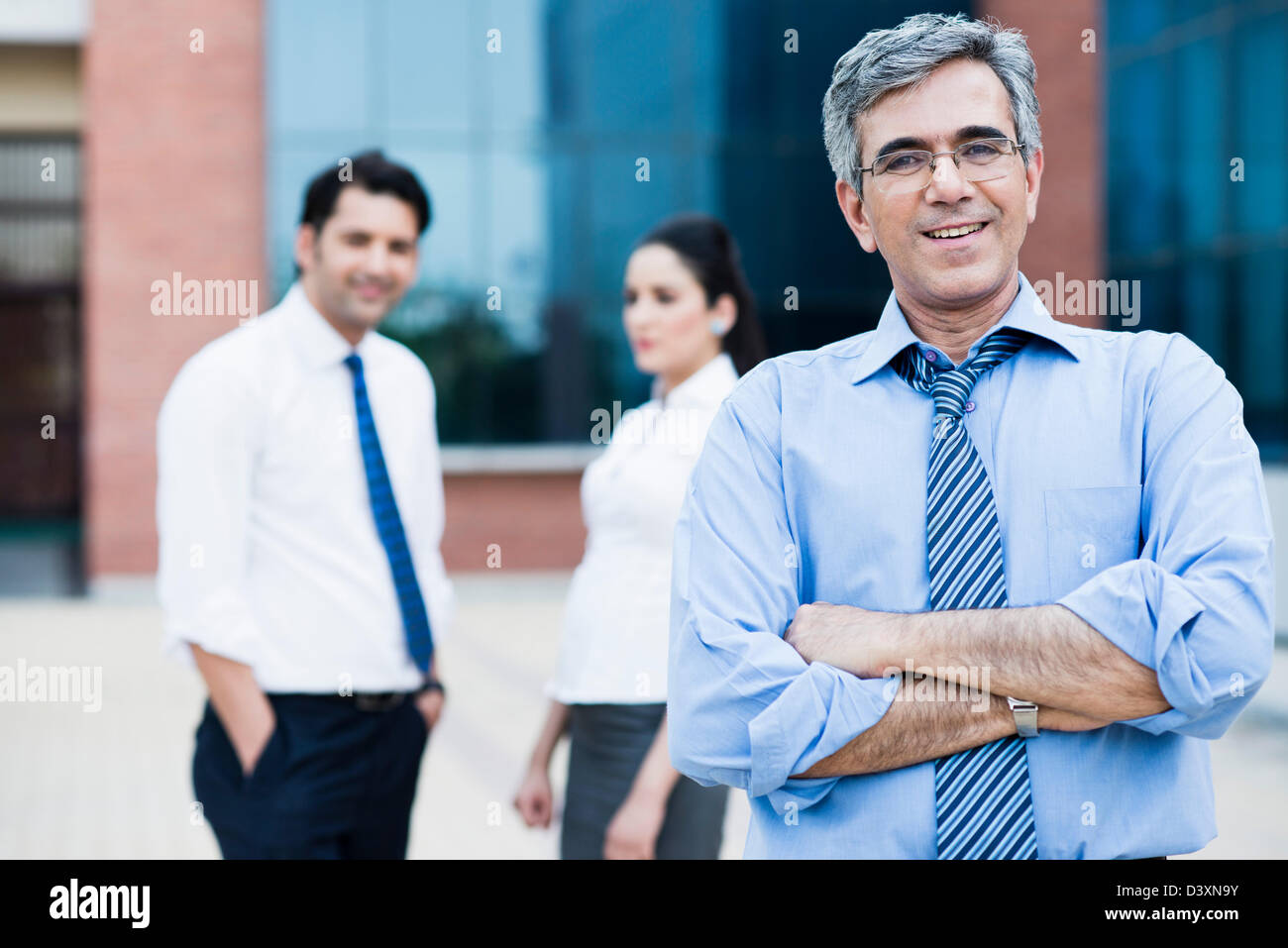 Portrait of a businessman with his colleagues standing behind him Stock ...