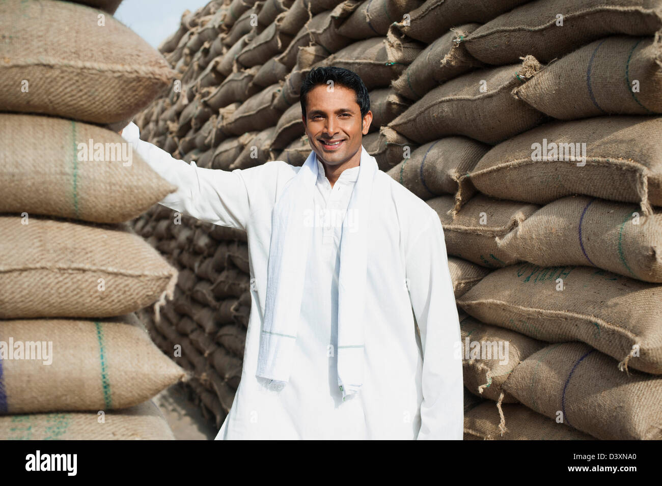Man standing near stacks of wheat sacks in a warehouse, Anaj Mandi ...