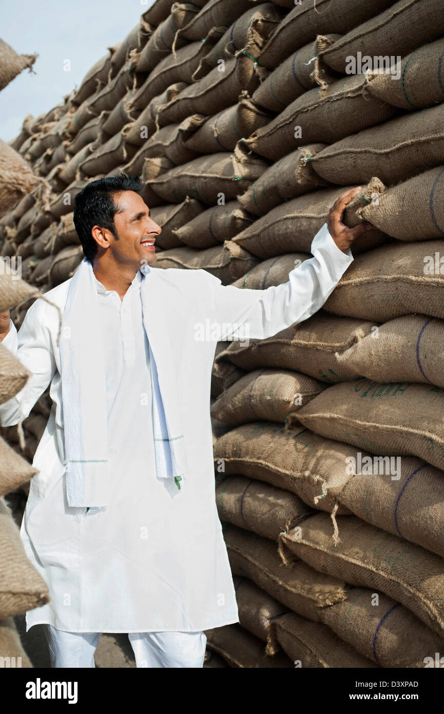 Man looking at stacks of wheat sacks in a warehouse, Anaj Mandi, Sohna ...