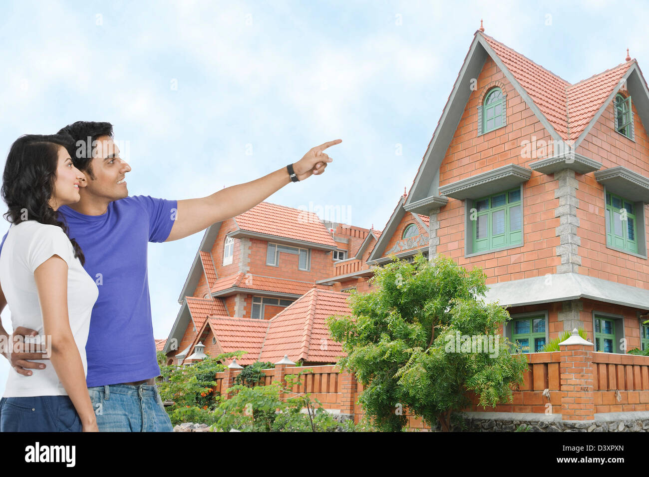 Man standing with his wife and pointing towards a house Stock Photo - Alamy
