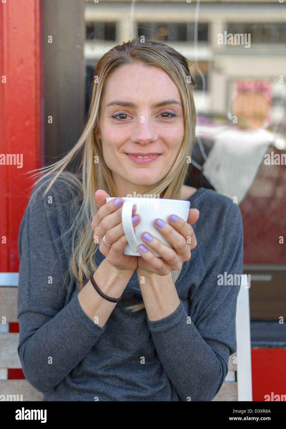 Attractive young lady having coffee at a cafe Stock Photo - Alamy