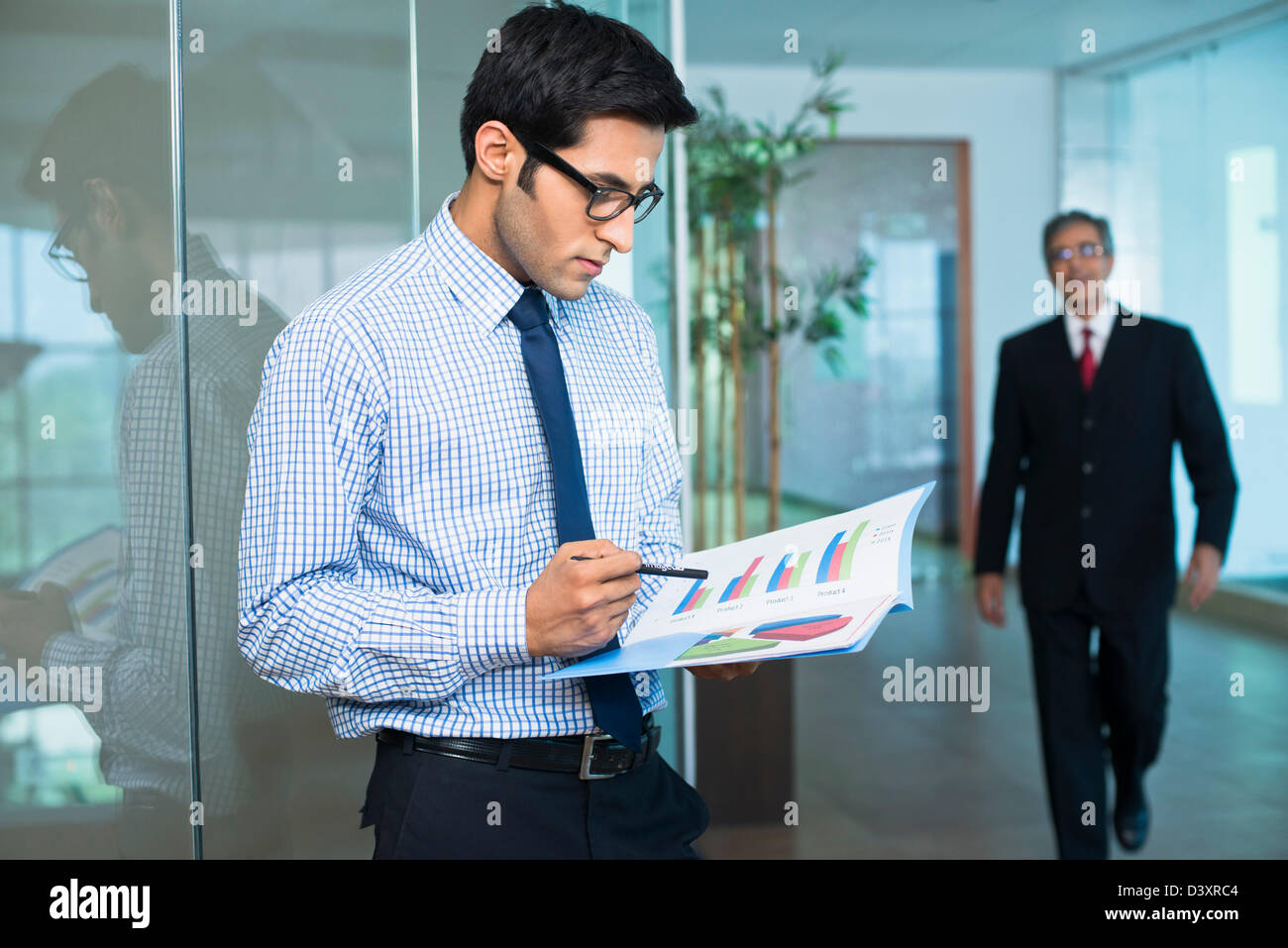 Businessman reading a report with his boss in the background Stock ...