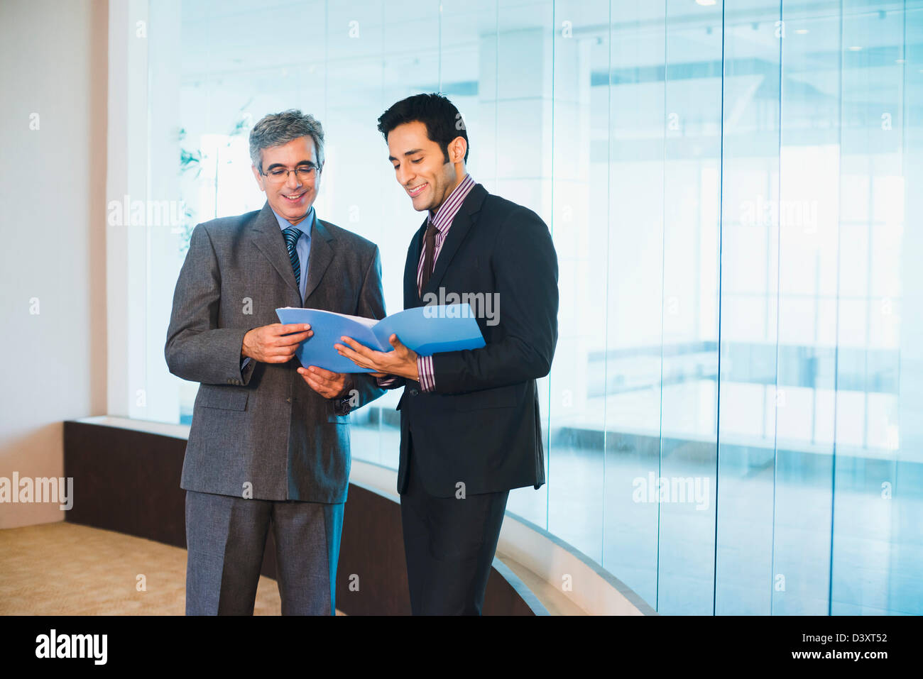 Businessman discussing a report with his colleague Stock Photo - Alamy