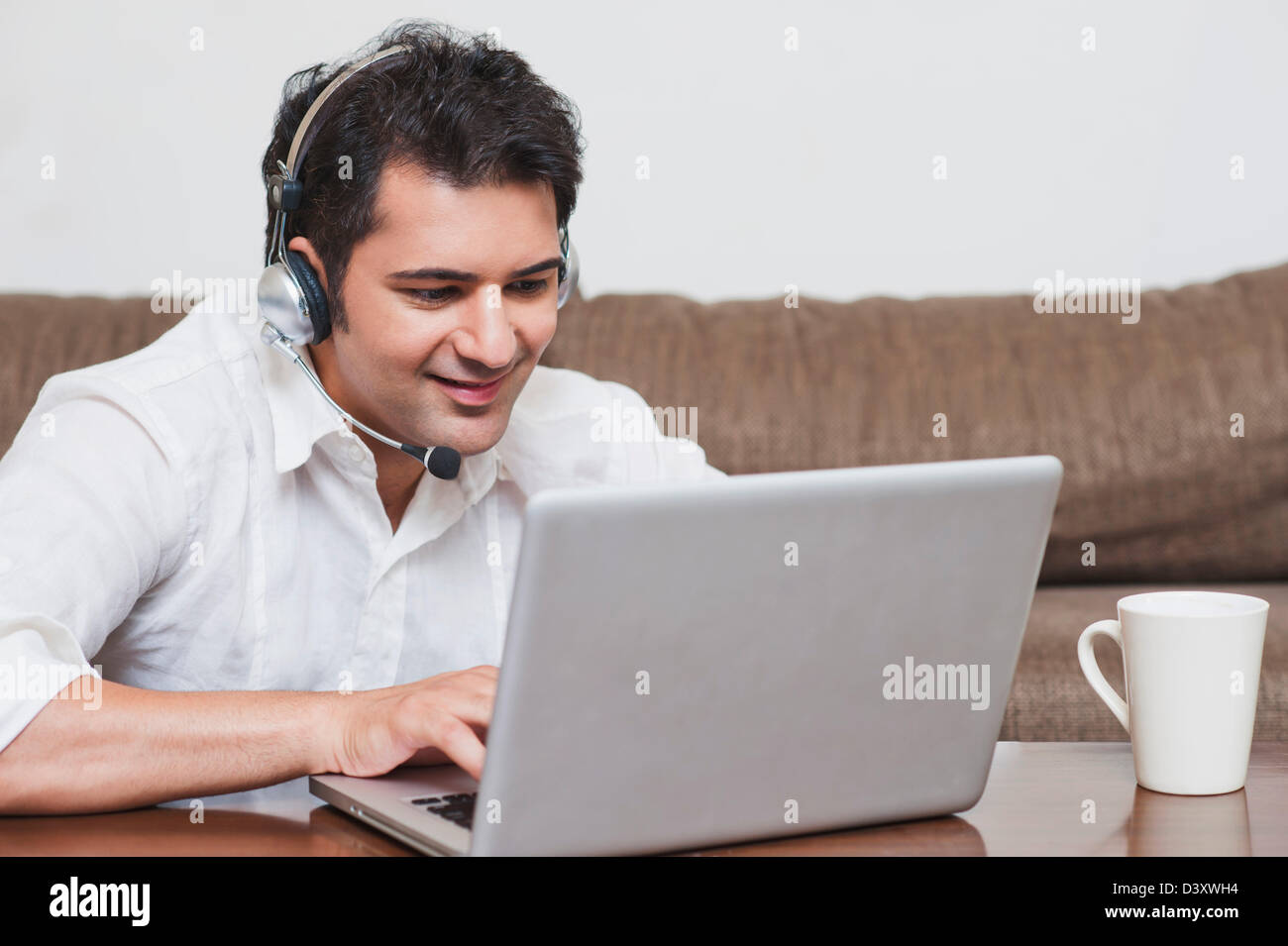 Customer service representative working on a laptop Stock Photo - Alamy