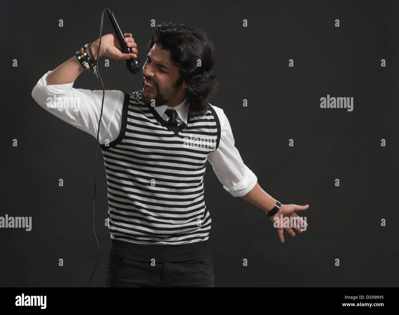 Singer holding a mike and singing Stock Photo - Alamy