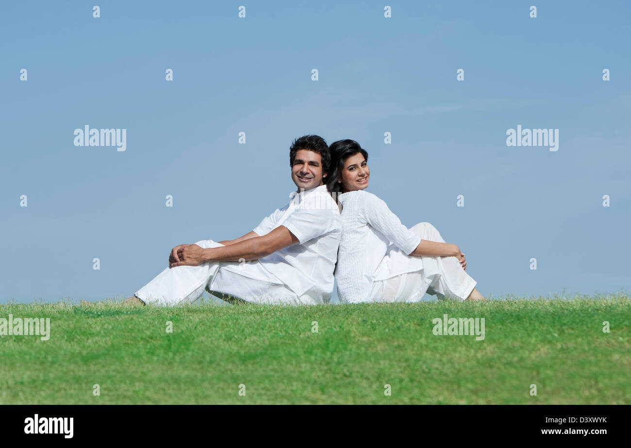 Couple sitting back to back in a park, Japanese Park, Rohini, Delhi ...