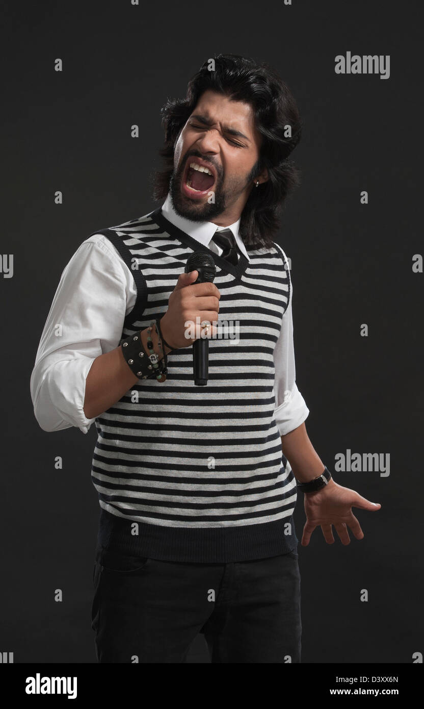 Singer holding a mike and singing Stock Photo - Alamy