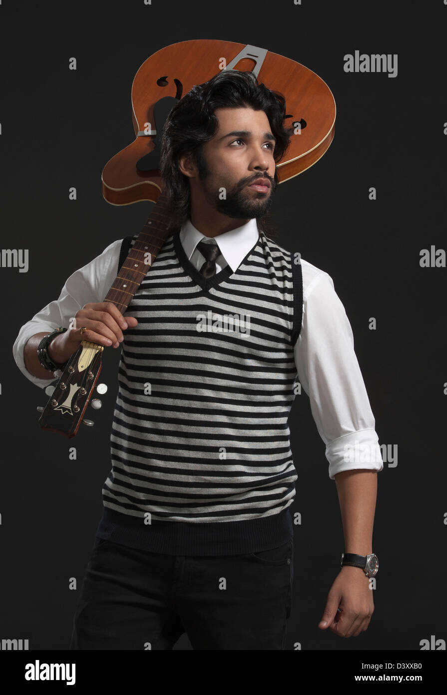 Musician holding a guitar and thinking Stock Photo - Alamy