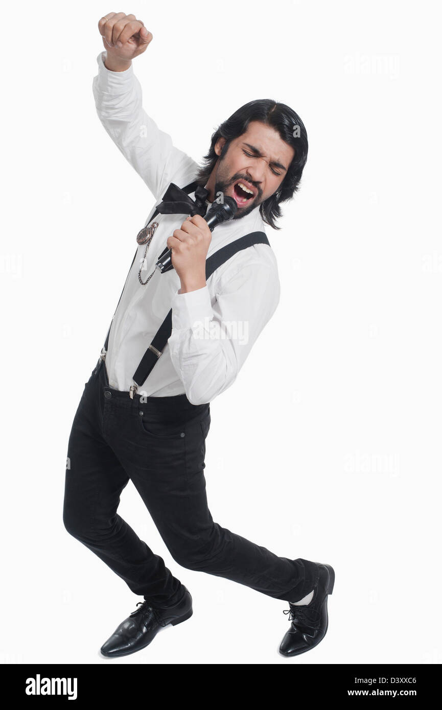 Singer holding a mike and singing Stock Photo - Alamy